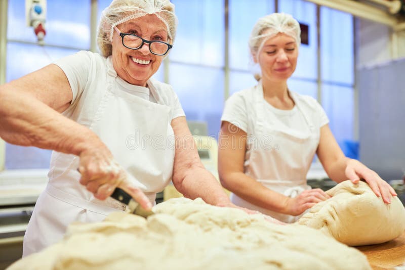 Two Female Bakers Cutting and Kneading the Dough Stock Image - Image of ...
