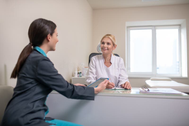 Two Female Doctors Sitting at the Table in the Office Stock Photo ...