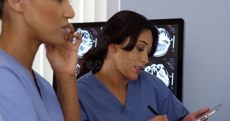 Two Female Doctors Using Tablet and Mobile Phone Stock Image - Image of ...