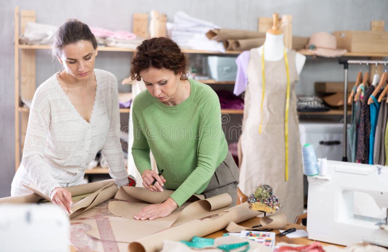 Two Female Dressmaker Draws Sketch of Future Clothing on Paper Using ...