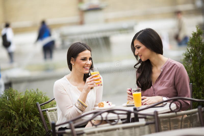 Two Female Friends Sitting Outside Stock Image - Image of together ...