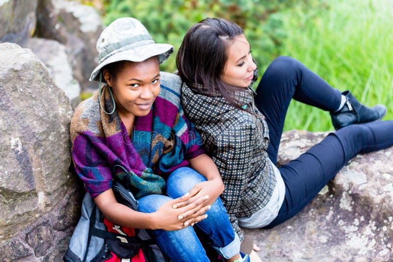 Two Female Friends Sitting on Rock Stock Image - Image of african ...