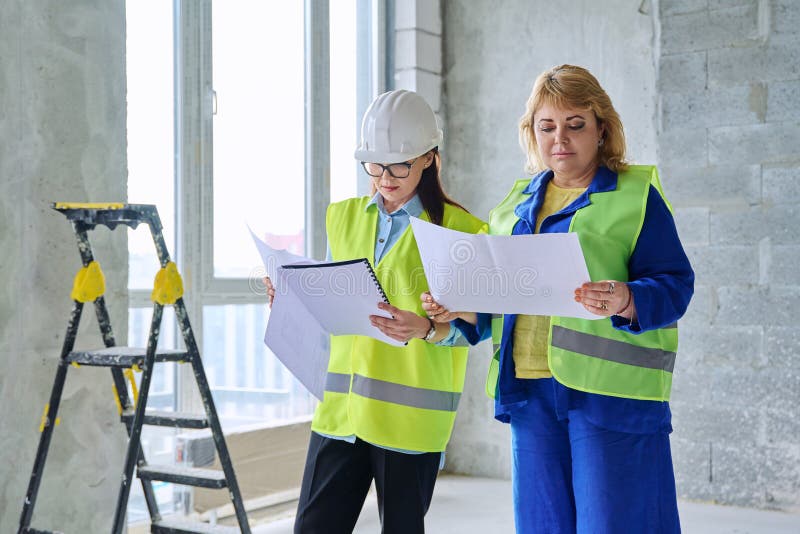 Two Female Industrial Workers at Construction Site Discussing Work ...