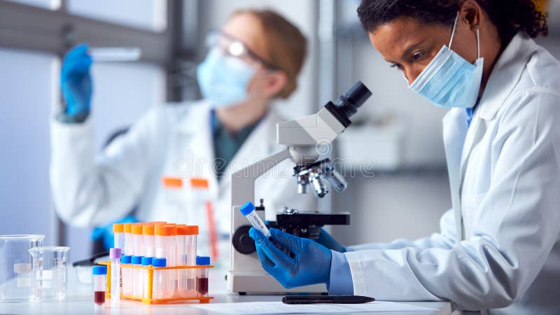 Two Female Lab Workers Wearing PPE Researching Covid-19 Vaccine in ...