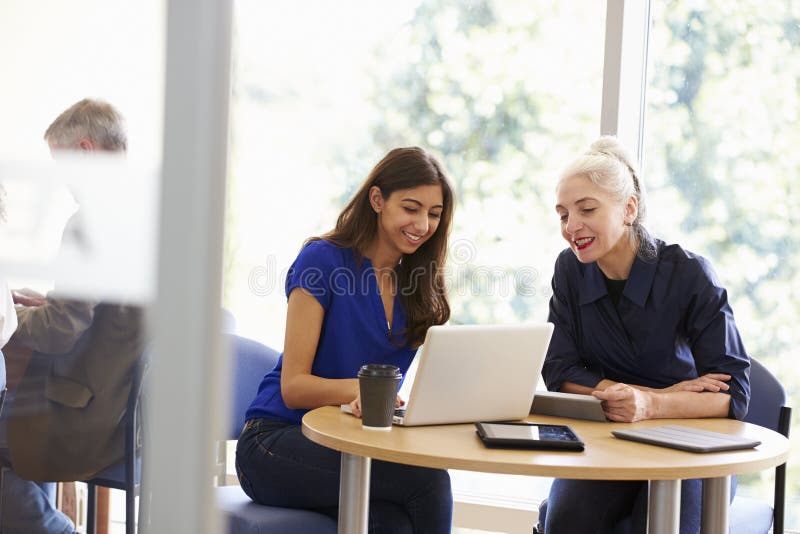 Two Female Mature Students Working Together Using Laptop Stock Photo ...