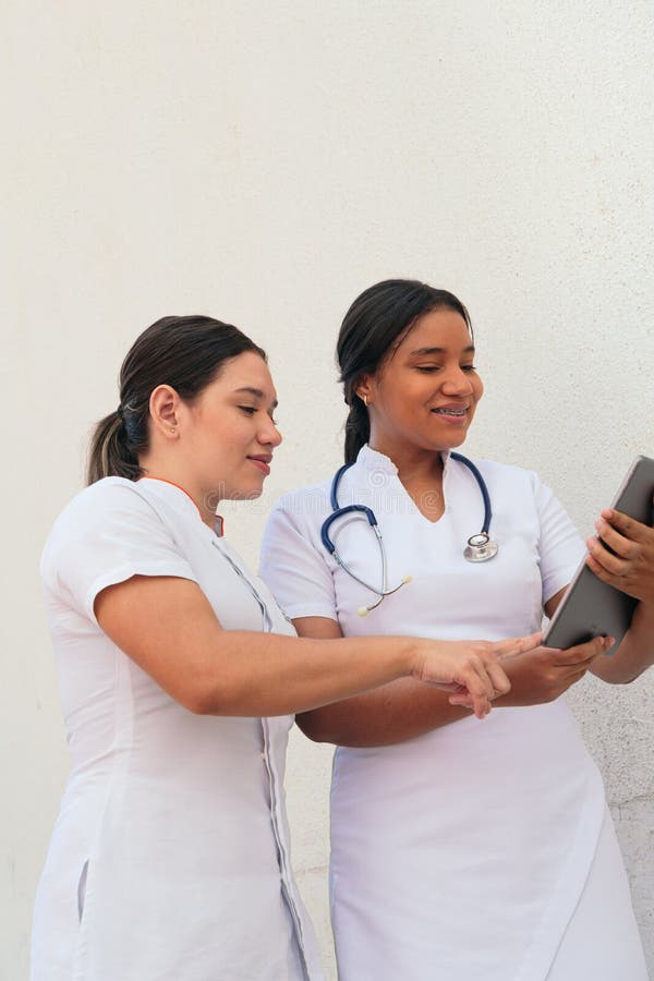 Two Female Nurses Discussing while Looking at Digital Tablet Stock ...