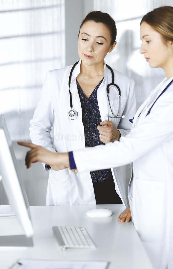 Two Female Physicians are Discussing Medical Therapy, while Standing at ...