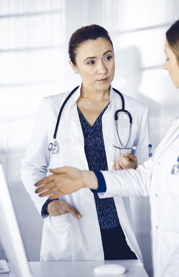 Two Female Physicians are Discussing Medical Therapy, while Standing at ...