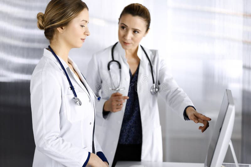 Two Female Physicians are Discussing Medical Therapy, while Standing at ...