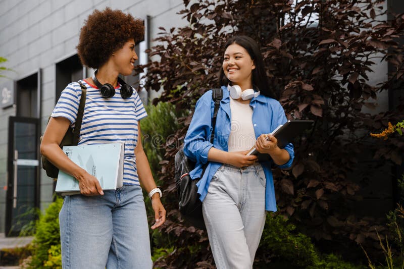 Two Female Students Smiling while Walking in University Campus Stock ...