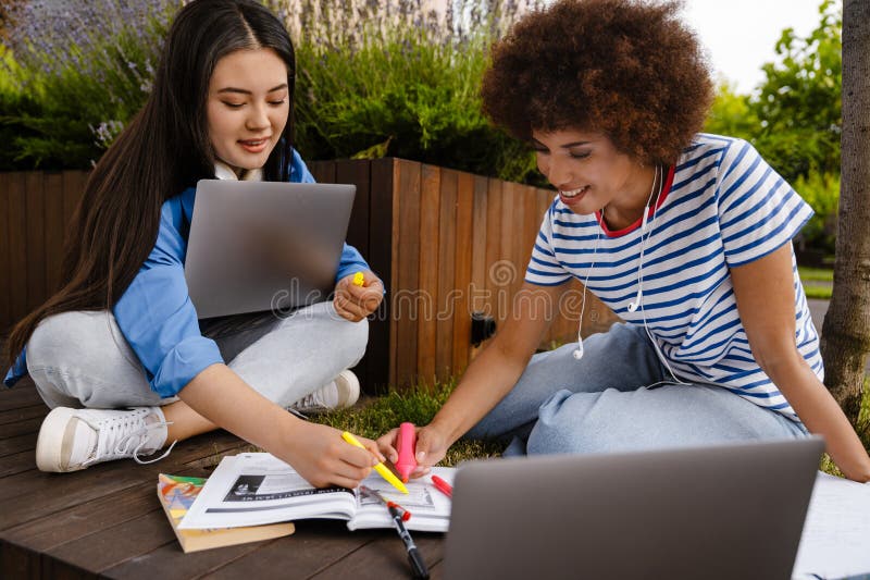Two Female Students Using Highlighting Pens on Books while Studying ...
