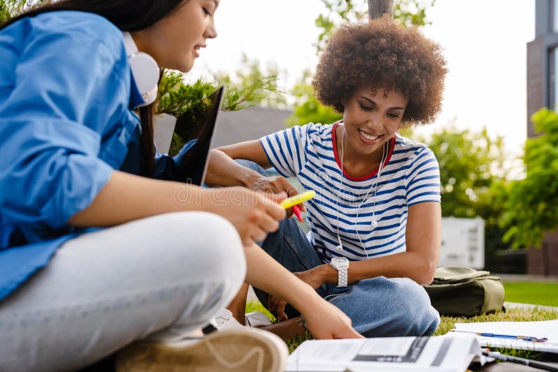 Two Female Students Using Highlighting Pens on Books while Studying ...