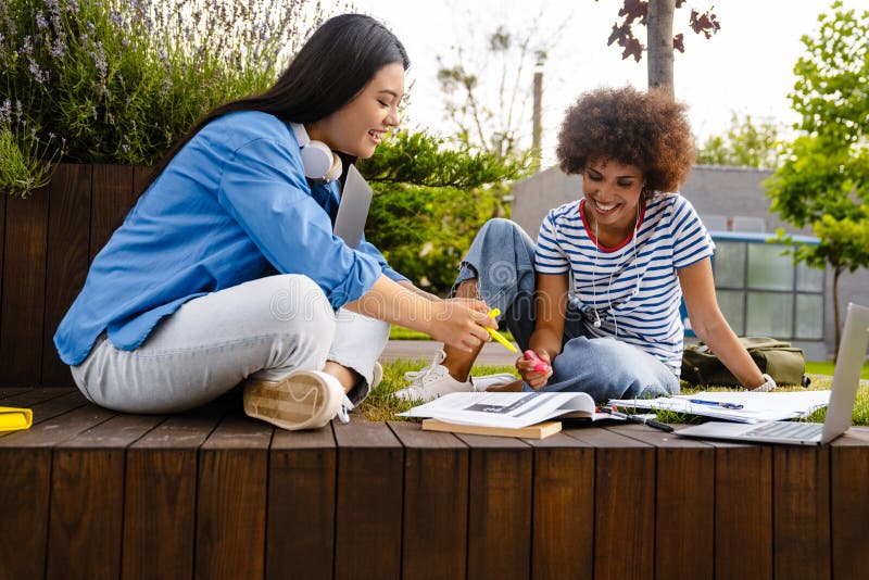 Two Female Students Using Highlighting Pens on Books while Studying ...