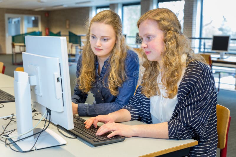 Two Female Students Working Together on Computer in Classroom Stock ...