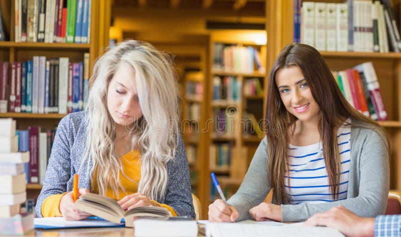 Two Female Students Writing Notes at Library Desk Stock Photo - Image ...
