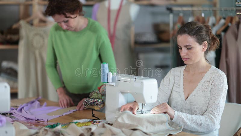 Two Female Tailors Work Together in a Sewing Workshop and Draw on Paper ...
