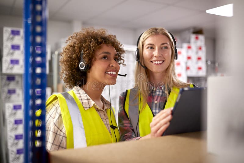 Two Female Workers Wearing Headsets in Logistics Distribution Warehouse ...