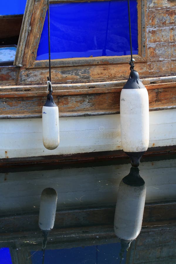 Two Fender on an Old Boat with Reflection in Water Stock Photo - Image ...