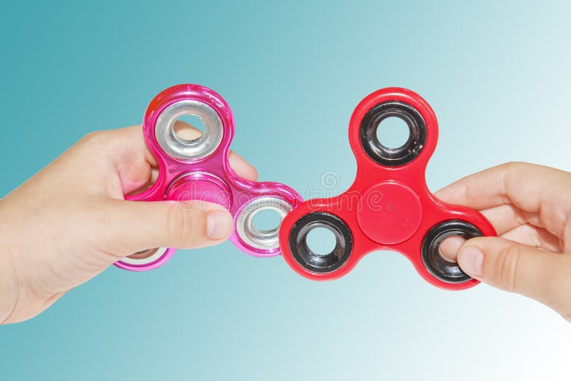 Two Fidget Spinners in Hand of Boy on Blue Background Stock Image ...