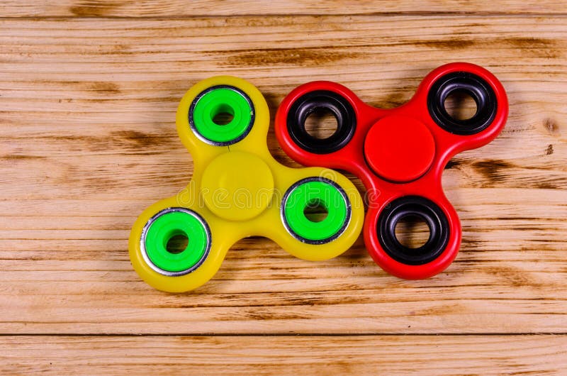 Two Fidget Spinners on Wooden Desk. Top View Stock Photo - Image of ...