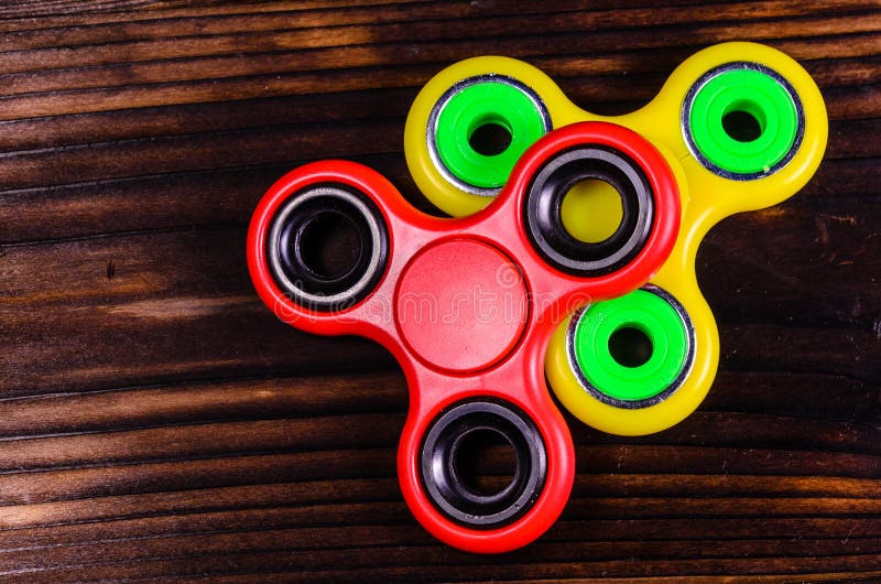 Two Fidget Spinners on Wooden Desk Stock Image - Image of hand, game ...