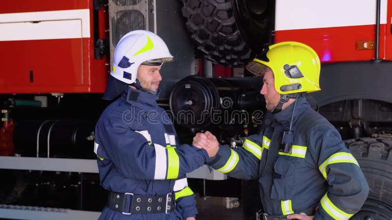 Two Firefighters in Protective Clothing in Helmets with Fire Engine ...