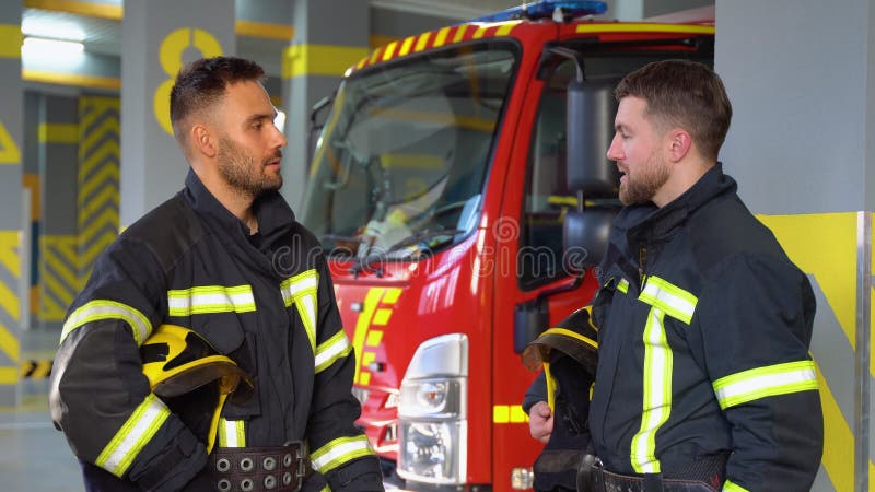 Two Firefighters Shake Hands at a Fire Station, Friendly Handshake ...