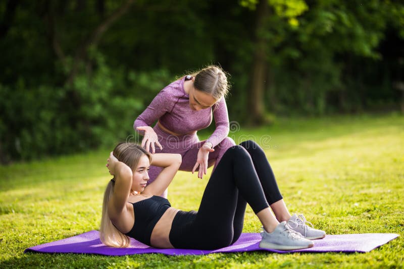 Two Fit Girlfriends Doing Partner Sit-up Exercise with High-five in ...