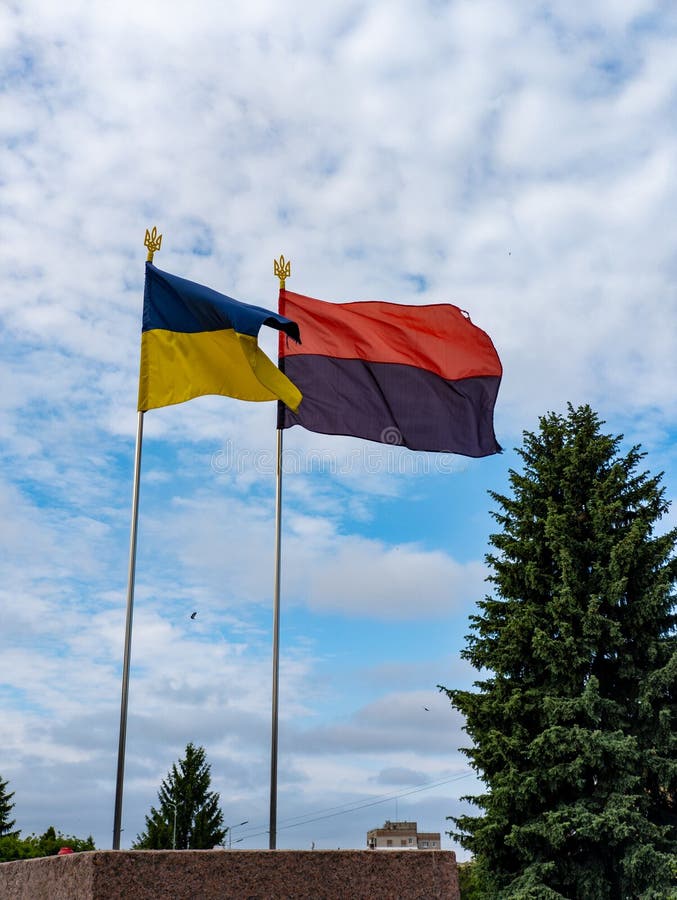 Two Flags Flying in the Wind on Top of a Stone Wall, Ukrainian Flag ...