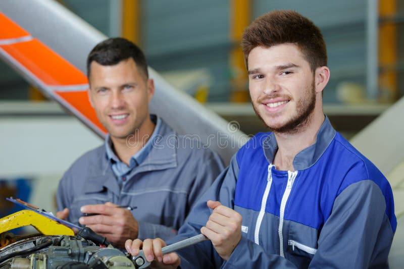 Two Flight Engineers Working in Aircraft Hangar Stock Image - Image of ...