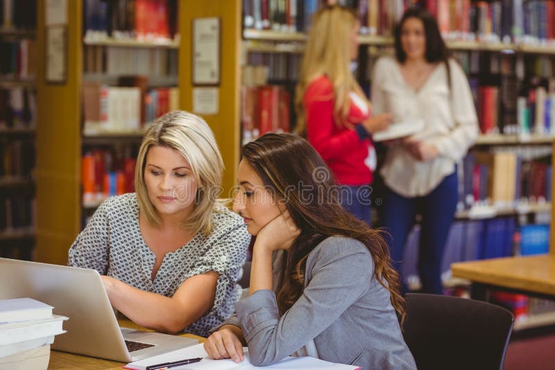Two Focused Students on Laptop with Classmates Behind Them Stock Image ...