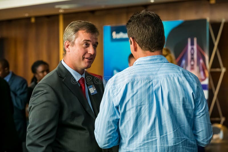 Two Formally Dressed Men Having a Conversation at a Networking Event ...