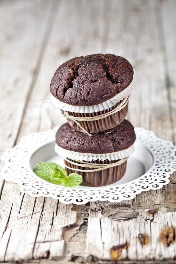 Two Fresh Dark Chocolate Muffins with Mint Leaves on White Plate on ...