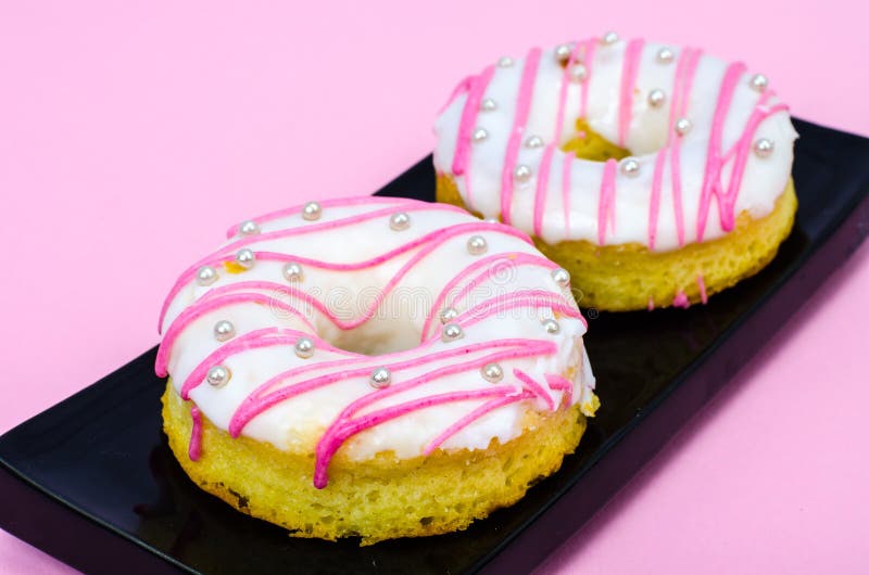 Two Fresh Round Donuts on Black Plate Stock Photo - Image of icing ...