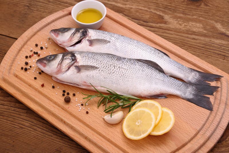 Two Fresh Sea Bass Fish on Cutting Board Stock Image - Image of gourmet ...