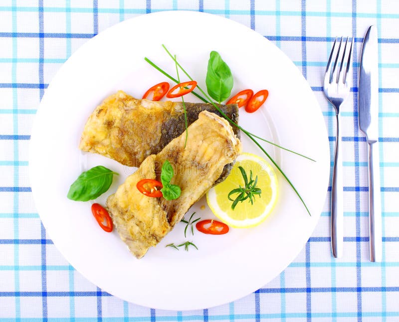Two Fried Fish Fillets with Lemon Slice on White Plate Stock Photo ...