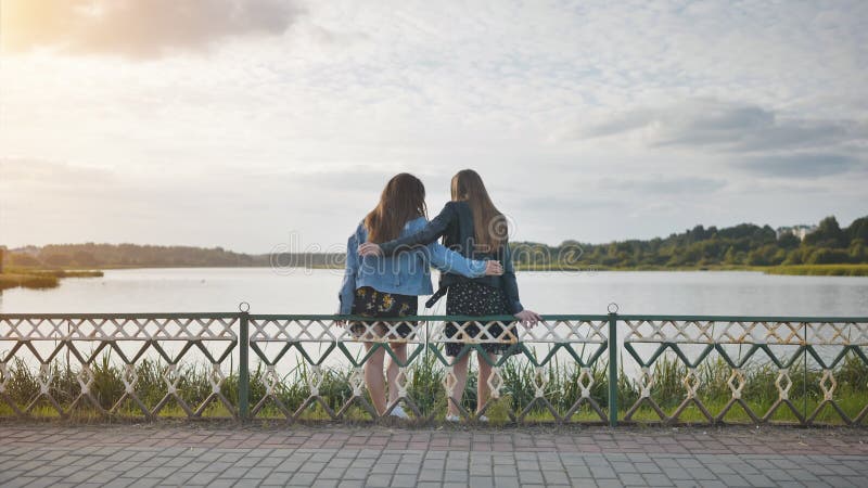 Two Friendly Friends Sit and Cuddle by the Lake. Stock Footage - Video ...