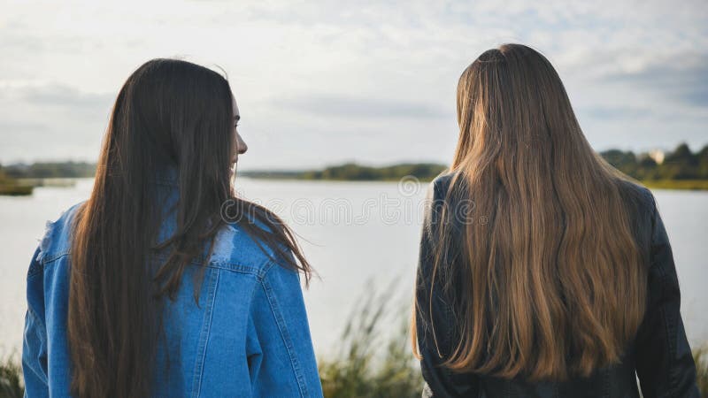 Two Friendly Friends Sit and Cuddle by the Lake. Stock Photo - Image of ...