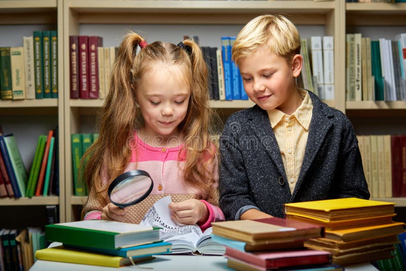 Two Friendly School Kids Discussing a Book Stock Photo - Image of stack ...