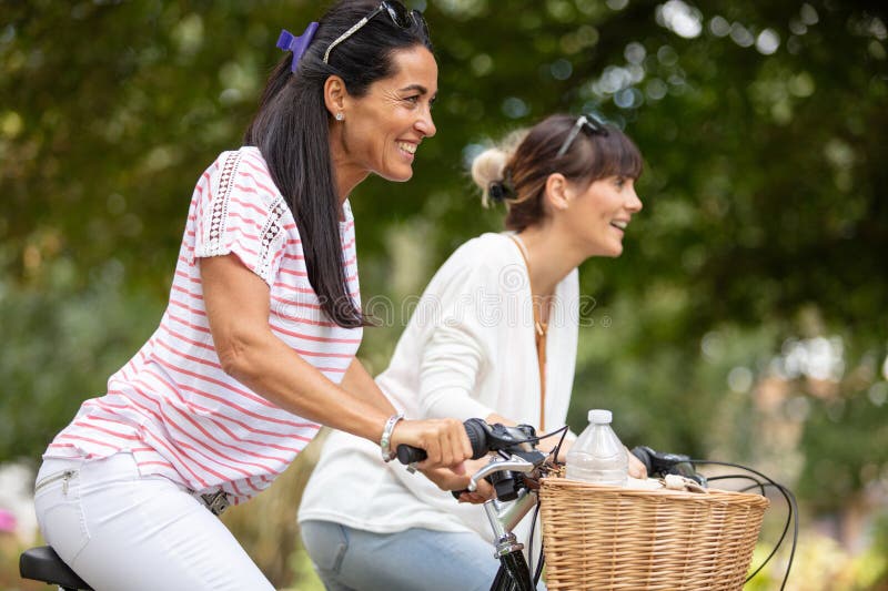 Two Friends on Bikes Outdoors Smiling Stock Photo - Image of park ...