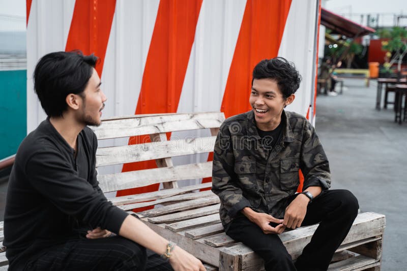 Two Friends Chatting Sitting on the Wooden Chair Stock Photo - Image of ...