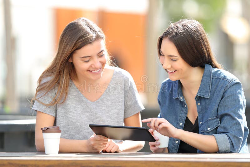 Two Friends Checking Tablet Content in a Park Stock Image - Image of ...