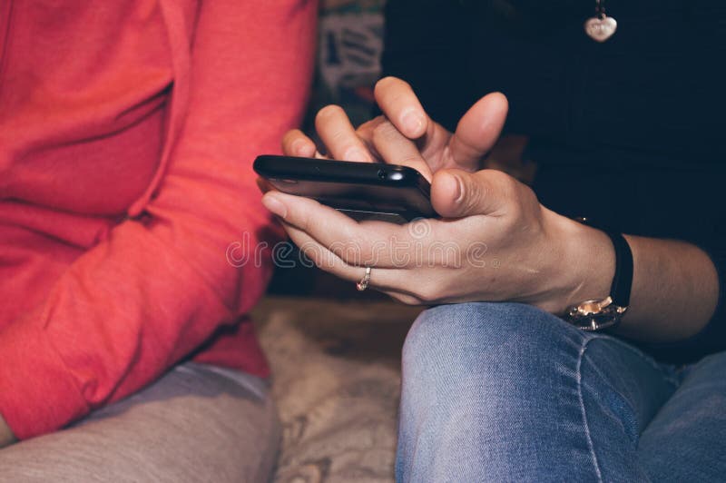 Two Friends Communicate, Holding Smartphone in Hands Stock Photo ...