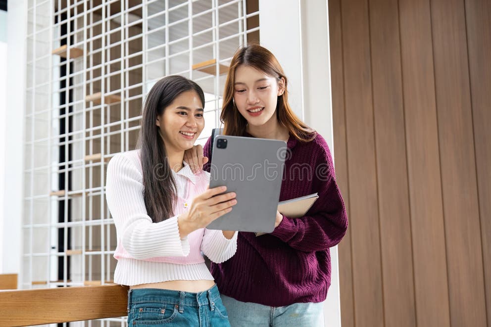 Study Time and Friendship. Two Students Sharing Study Materials while ...