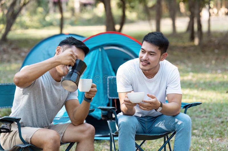 Two Friends Enjoying Coffee Outdoors while Camping in a Scenic Forest ...