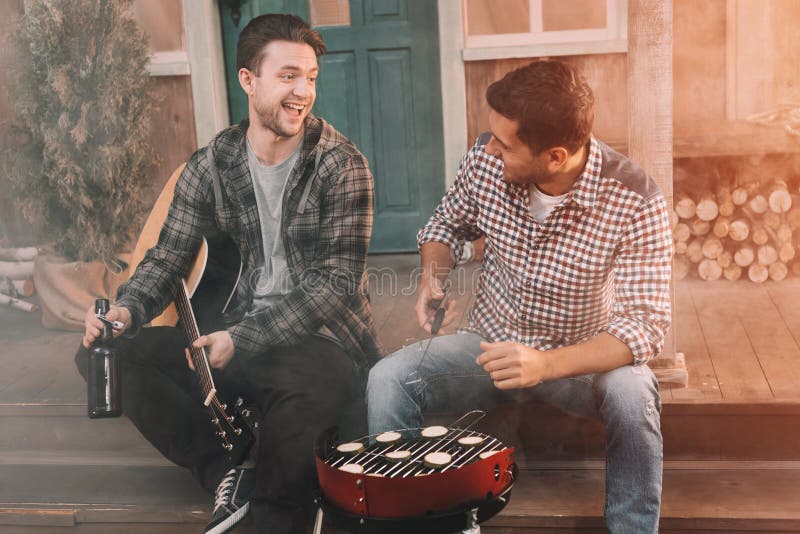 Two Friends with Guitar and Beer Making Barbecue Stock Photo - Image of ...