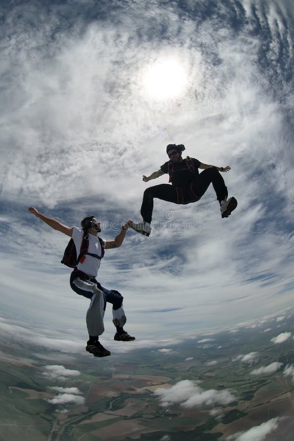Two Friends Having Fun in Freefall. Against the Sun Stock Image - Image ...