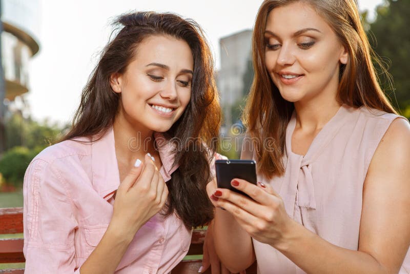 Two Friends Looking at Pictures on a Cellphone Stock Photo - Image of ...