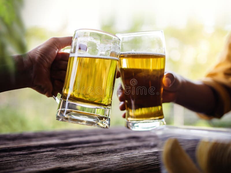 Two Friends Making Cheers with Glasses and Drinking Beer Stock Photo ...