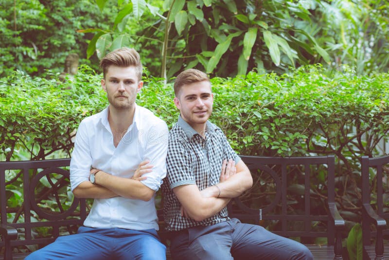 Two Friends Men Talking Sitting in a Garden. Stock Image - Image of ...